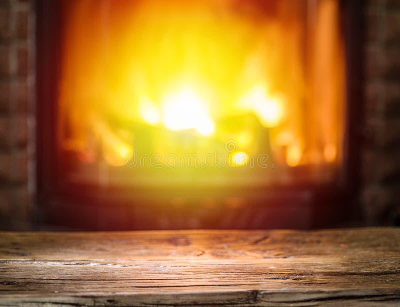 Old Wooden Table and Fireplace with Warm Fire on the Background Stock ...