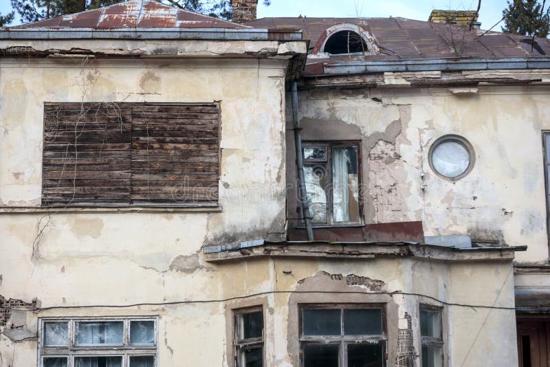 .an Old, Worn-out Building Facade with Several Windows and Doors ...