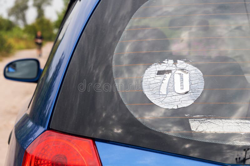 Old Worn Out Sticker 70 on the Rear Window of a Car Stock Photo - Image ...