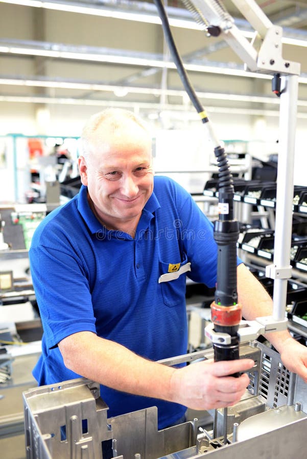 Older Friendly Worker in an Industrial Company Assembles Electronic ...