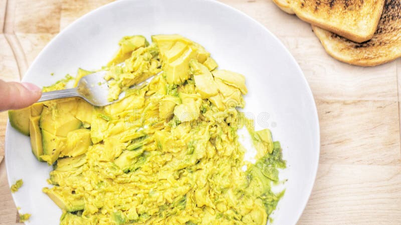 Older Man Mashes an Avocado Using a Fork Point of View Stock Photo ...
