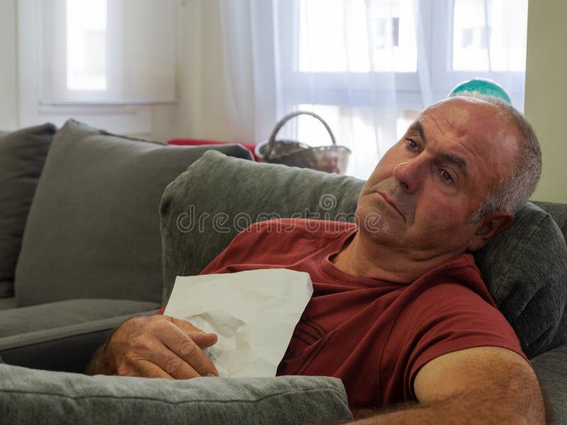 Older Man Sitting Alone on a Sofa with a Letter in His Hand Crying ...