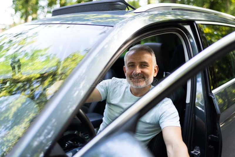 An Older Man Smiling in the Camera while he Prepares To Drive a Car ...