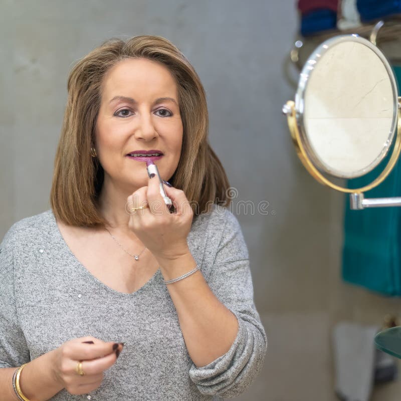 Older White Woman Painting Her Lips in Front of the Mirror of Her Bath ...