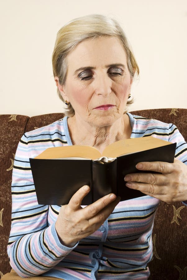 Older woman reading a book stock photo. Image of gray - 12224456