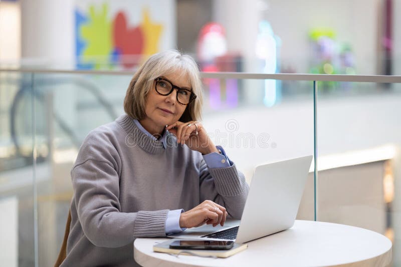 Older Woman Working on a Laptop at a Modern Workspace during the Day ...