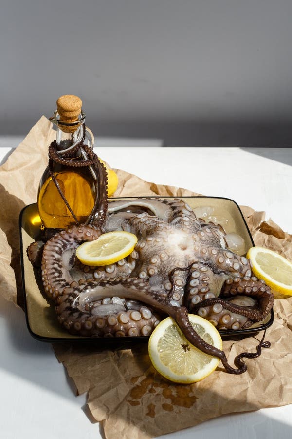 Olive Oil with Raw Octopus on a Plate with Lemons Ready for Preparing ...