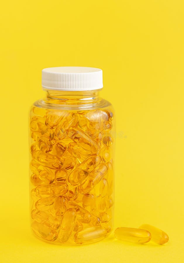 Omega 3 Fish Oil Capsules in a Container on Yellow Background. Copy ...