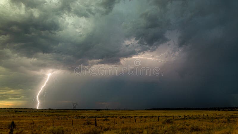 A Powerful Lightning Bolt Strikes the Ground in an Open Field Below ...