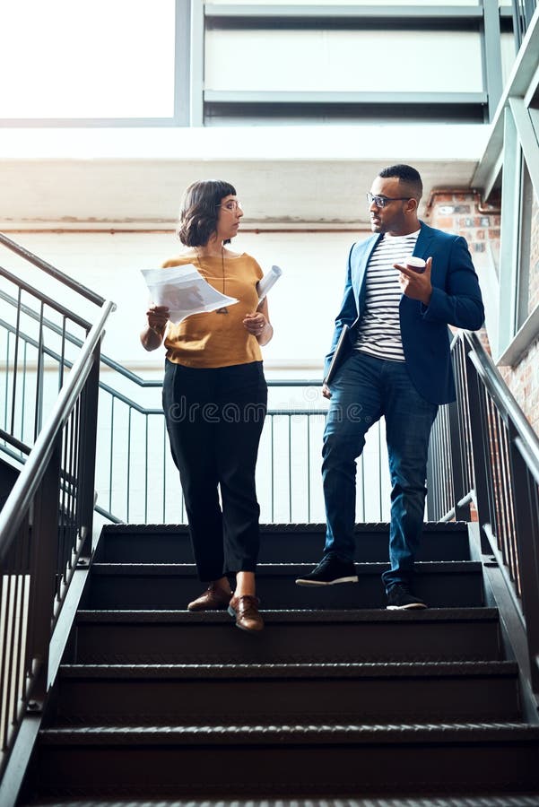 Once they Visualize Success, Its All Theirs. Two Designers Having a Discussion on a Staircase in ...