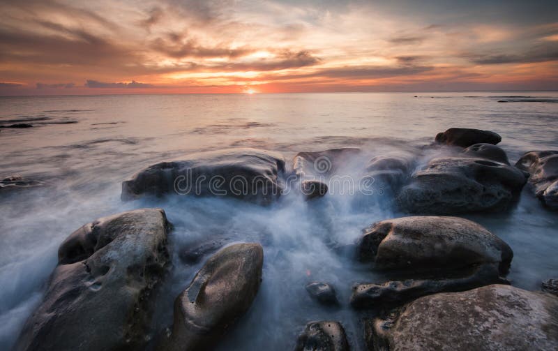 Onde E Tramonto Delle Rocce Della Spiaggia Fotografia Stock - Immagine ...
