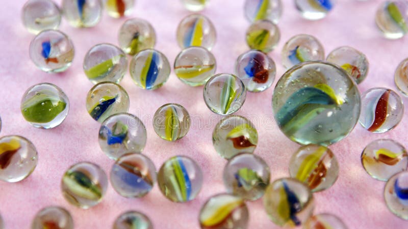 One Big Marble and Small Ones on Pink Table Stock Image - Image of ...