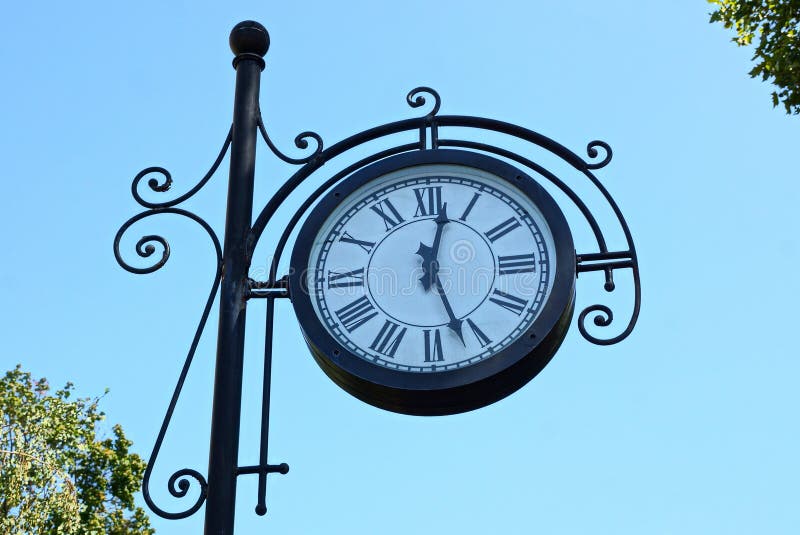 Big Round Clock on a Black Pillar Against a Blue Sky Stock Image ...