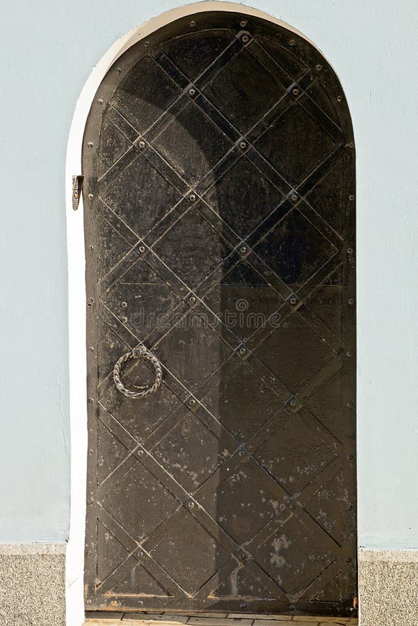 One Black Old Iron Door with a Wrought Iron Pattern on a White Stone ... One Black Old Iron Door with a Wrought Iron Pattern on a White Stone ...