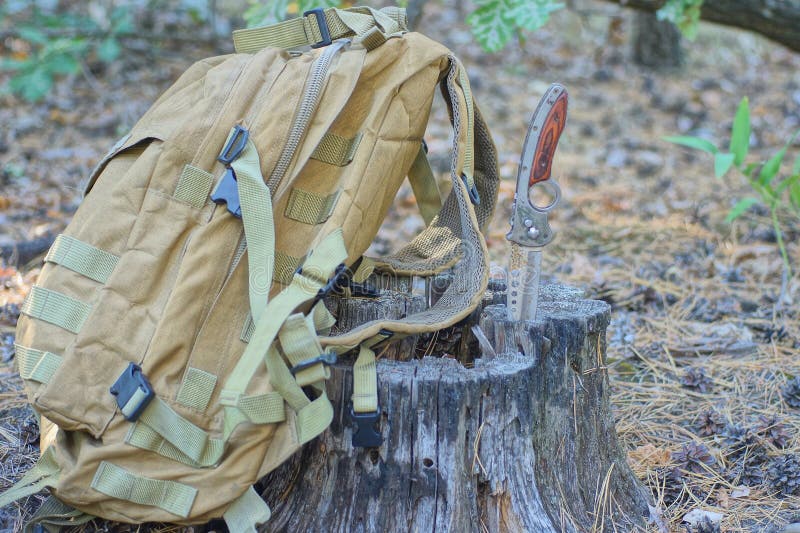 One Brown Army Backpack and a Folding Knife Standing on a Earth Stock ...