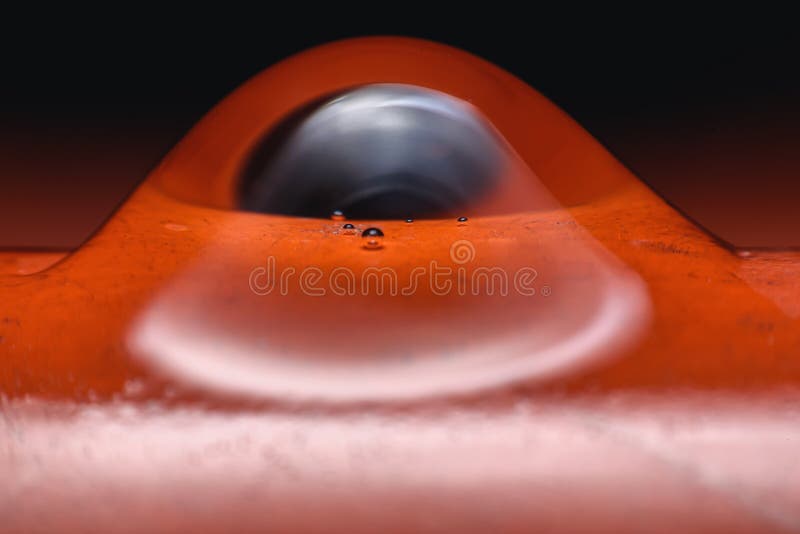 One Drop of Water is Dropping Over a Red Object with a Black Background ...