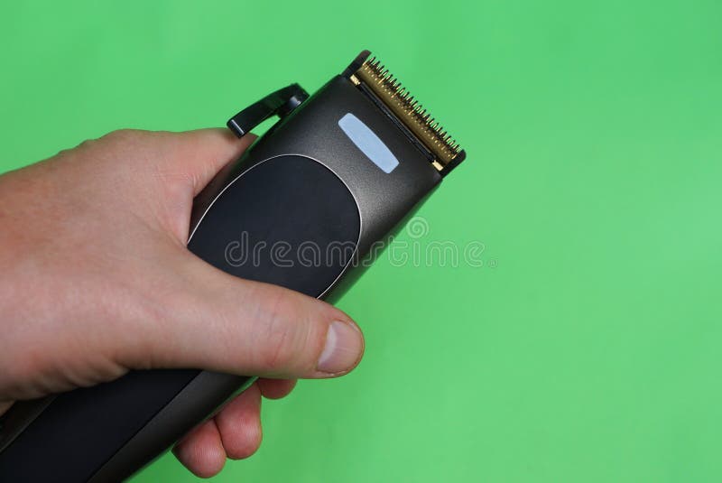 Electric Black Clipper in Hand on a Green Background Stock Image ...