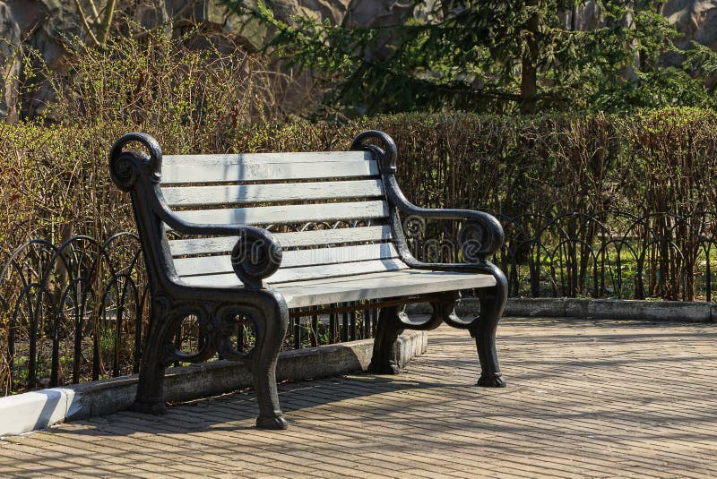 Gray Wooden Bench Stands on the Sidewalk in the Park Stock Image ...