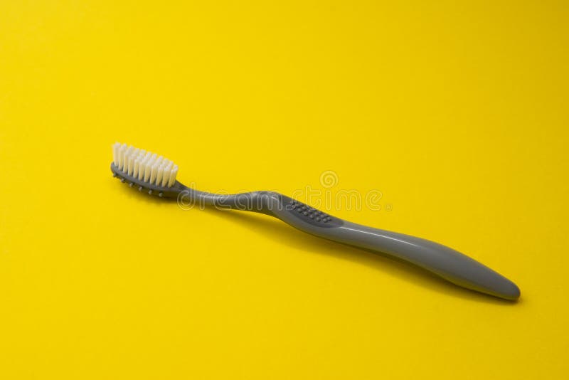 One Grey Toothbrush for Teeth on a Yellow Background. Stock Image ...