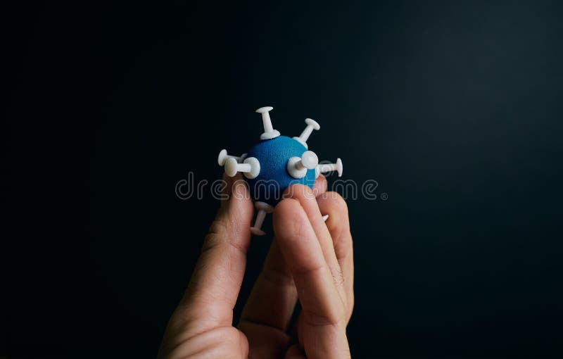 One Hand Has Some Models of Coronavirus on a Black Background with ...