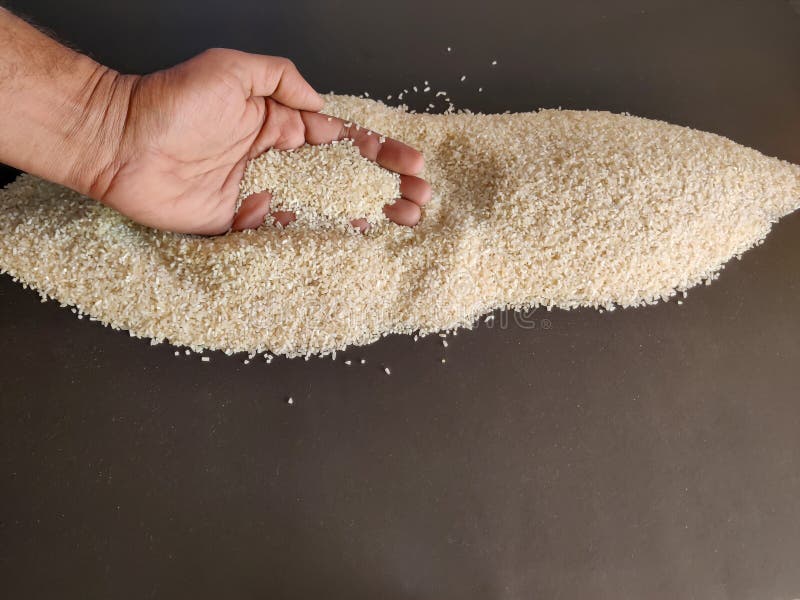 One Hand is in the Rice Which is on a Brown Background Stock Image ...
