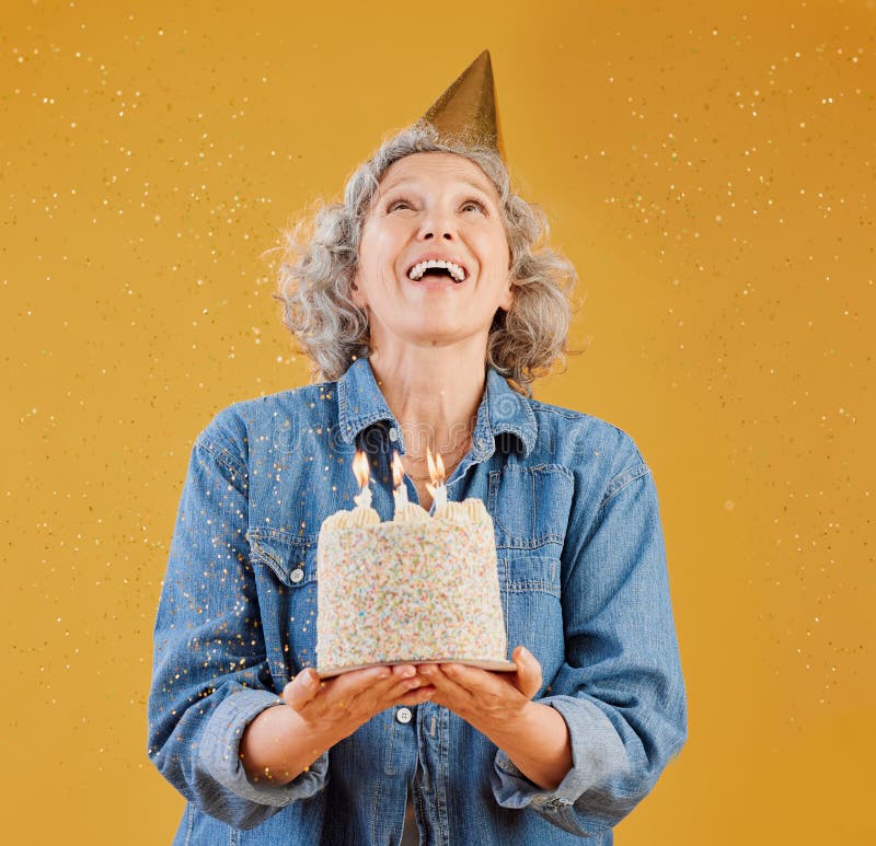 One Happy Mature Caucasian Woman Wearing A Birthday Hat And Holding A