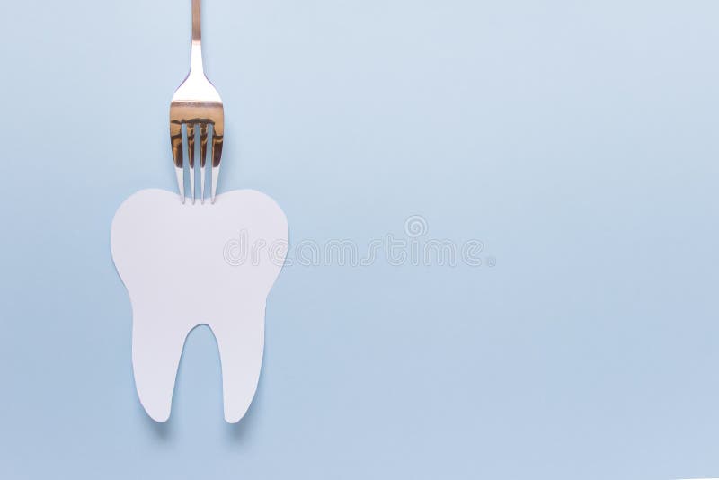 One Large Paper Tooth with Metallic Silver Fork on Blue Background ...