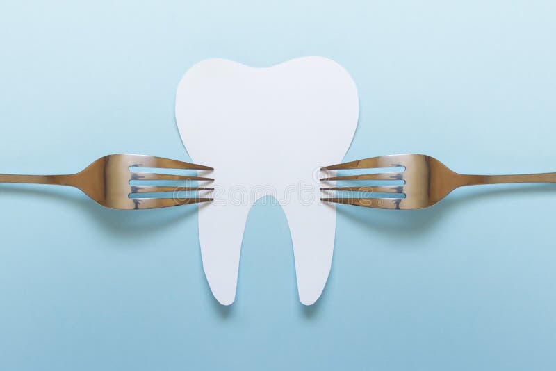 One Large Tooth with Two Metallic Forks on Blue Background Stock Image ...