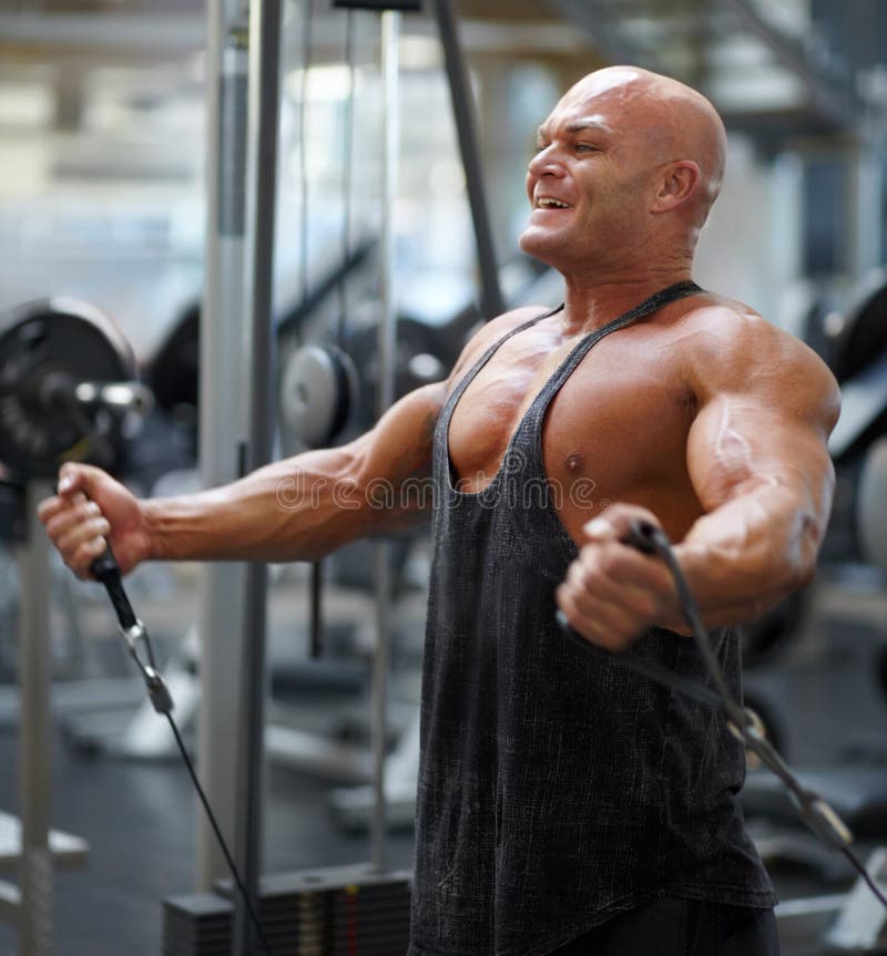One Last Rep. a Male Bodybuilder Using Exercise Equipment To Train at ...