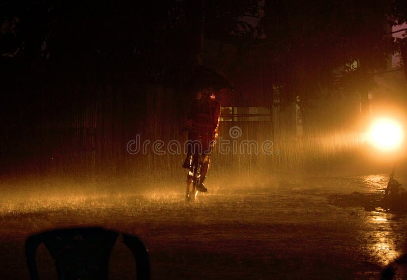 One Man Riding a Bicycle at Night with Heavy Rainfall Stock Image ...