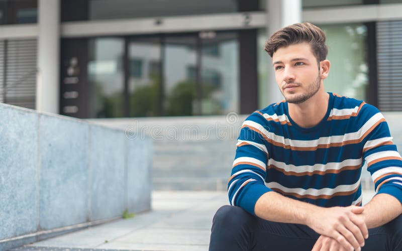 One Man Sitting Relaxed in Front of Building. One Young Handsome Guy ...