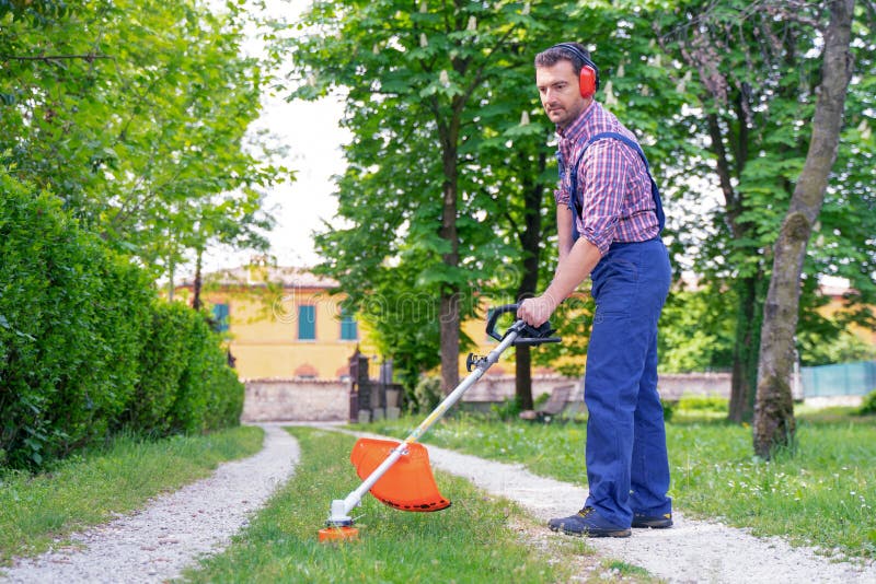 One Man Working in Garden and Mowing Grass Using Brush Cutter Stock ...