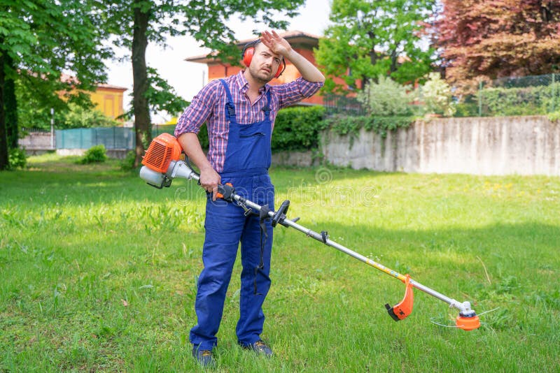 One Man Working in Garden and Mowing Grass Using Brushcutter Stock ...