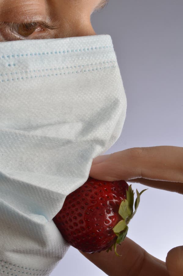 Eating a Strawberry through a Face Mask Stock Photo - Image of struggle ...