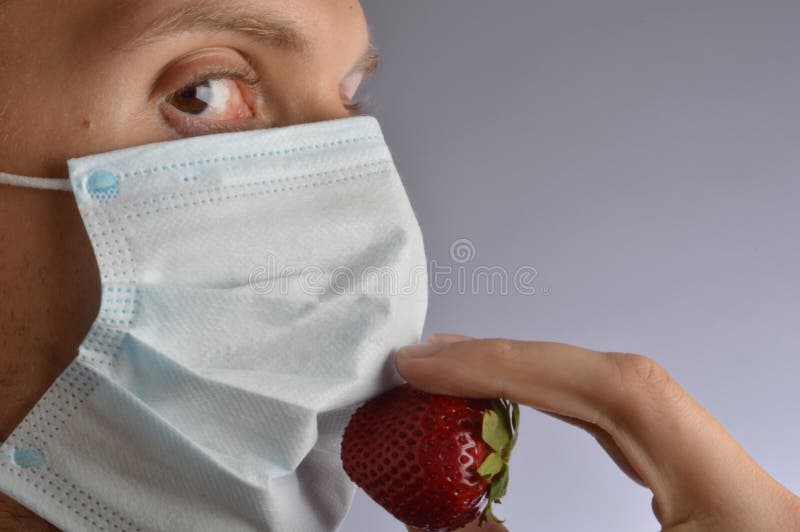 Eating a Strawberry through a Face Mask Stock Photo - Image of person ...