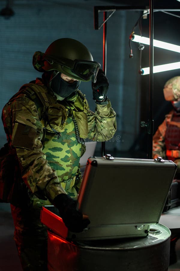 A Hacker in a Uniform Sits at a Computer with a Number of Monitors on ...
