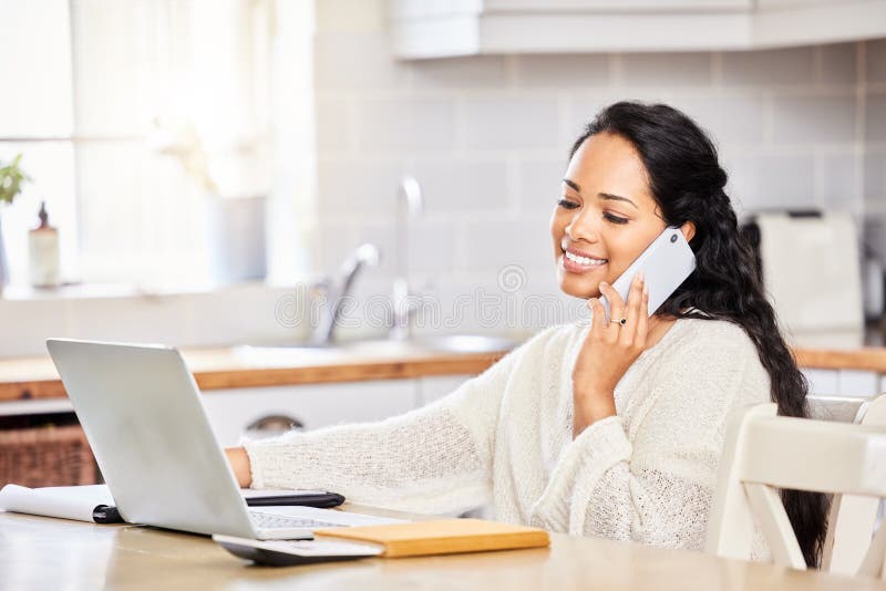 One Mixed Race Woman Working Remotely Using a Laptop and Talking on a ...