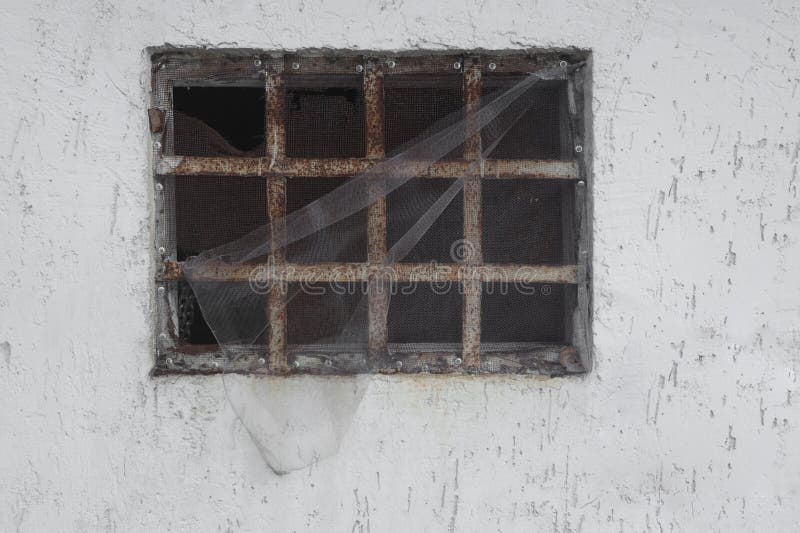 One Old Gray Window Behind Rust Eaten Iron Grating on a White Concrete ...