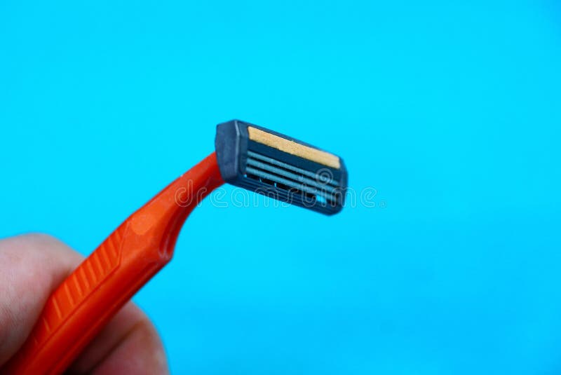 Red Razor in Hand on a Blue Background Stock Image - Image of ...