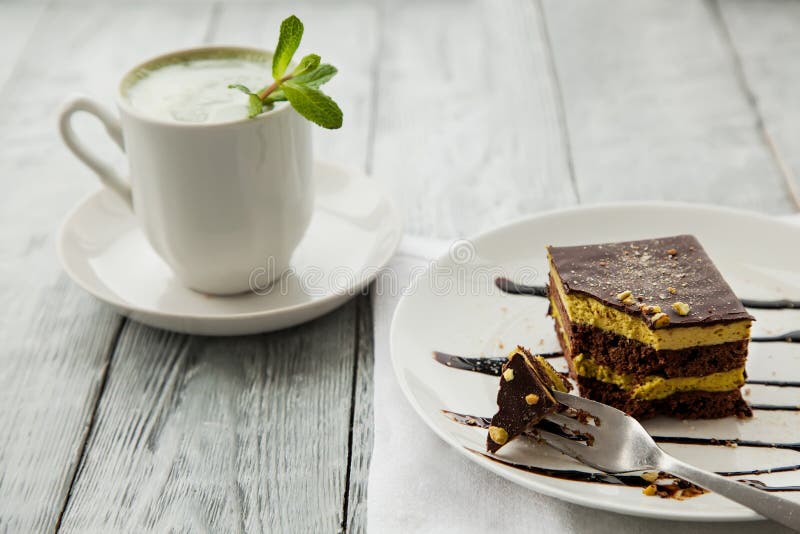 Piece of Austrian Three-layer Cake and Cup of Matcha Tea on a White ...