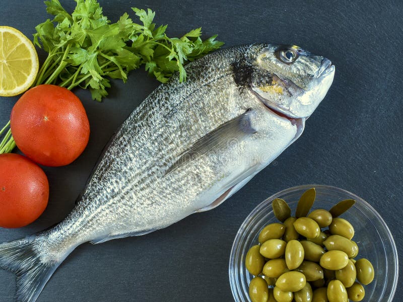 One Ready To Cook Raw Bream Fish with Vegetables on Stone Slate Stock ...