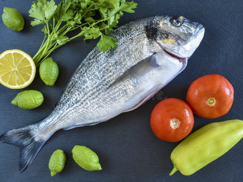 One Ready To Cook Raw Bream Fish with Vegetables on Stone Slate Stock ...