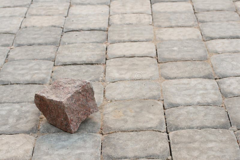 One Red Granite Cobblestone on a Pavement are Ready To Be Laid in the ...