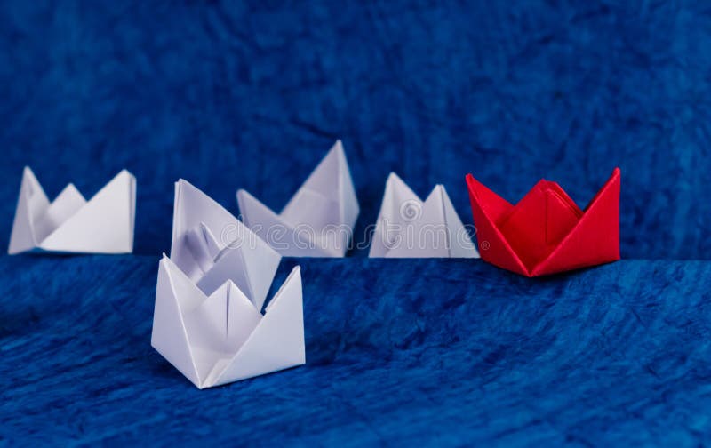 One Red Paper Boat Riding with the Sea Tides and White Boats Deviated ...