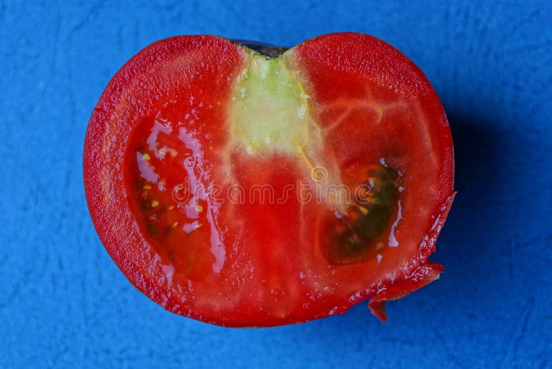 Red Sliced Tomato Lies on a Blue Table Stock Image - Image of macro ...