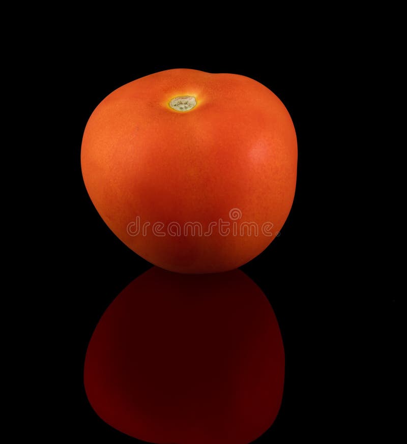 One Ripe Tomato on a Black Background with Reflection Stock Photo ...