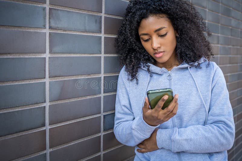 One Sad Young Black Girl Texting Alone on Mobile Phone Stock Photo ...