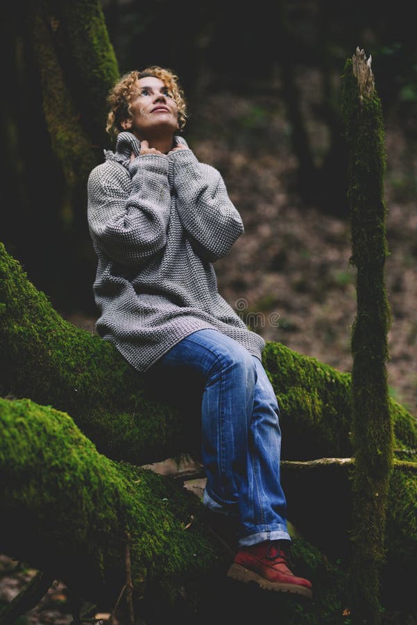 One Serene Happy Woman Sitting On A Green Wild Tree Trunk Looking Up And Enjoying Nature