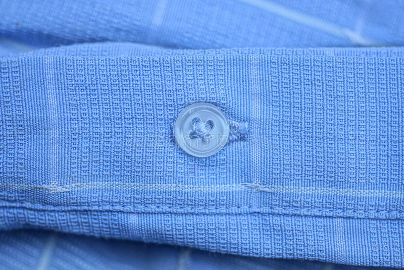 One Small Plastic White Button on a Piece of Blue Cloth Stock Image ...