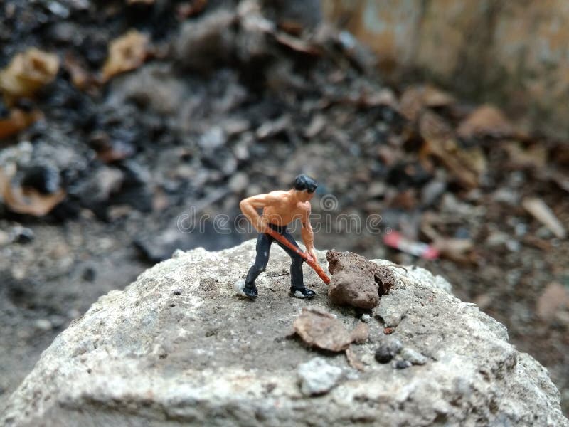 One Small Worker Lifting Stone Using Shovel in Front of Burned Trash ...